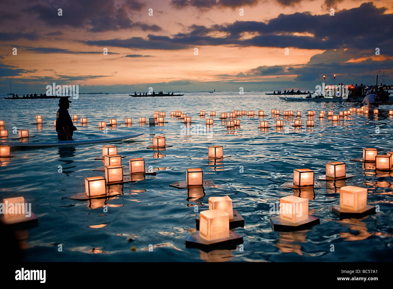Floating lanterns drift lazily in the water as the sun sets over ...