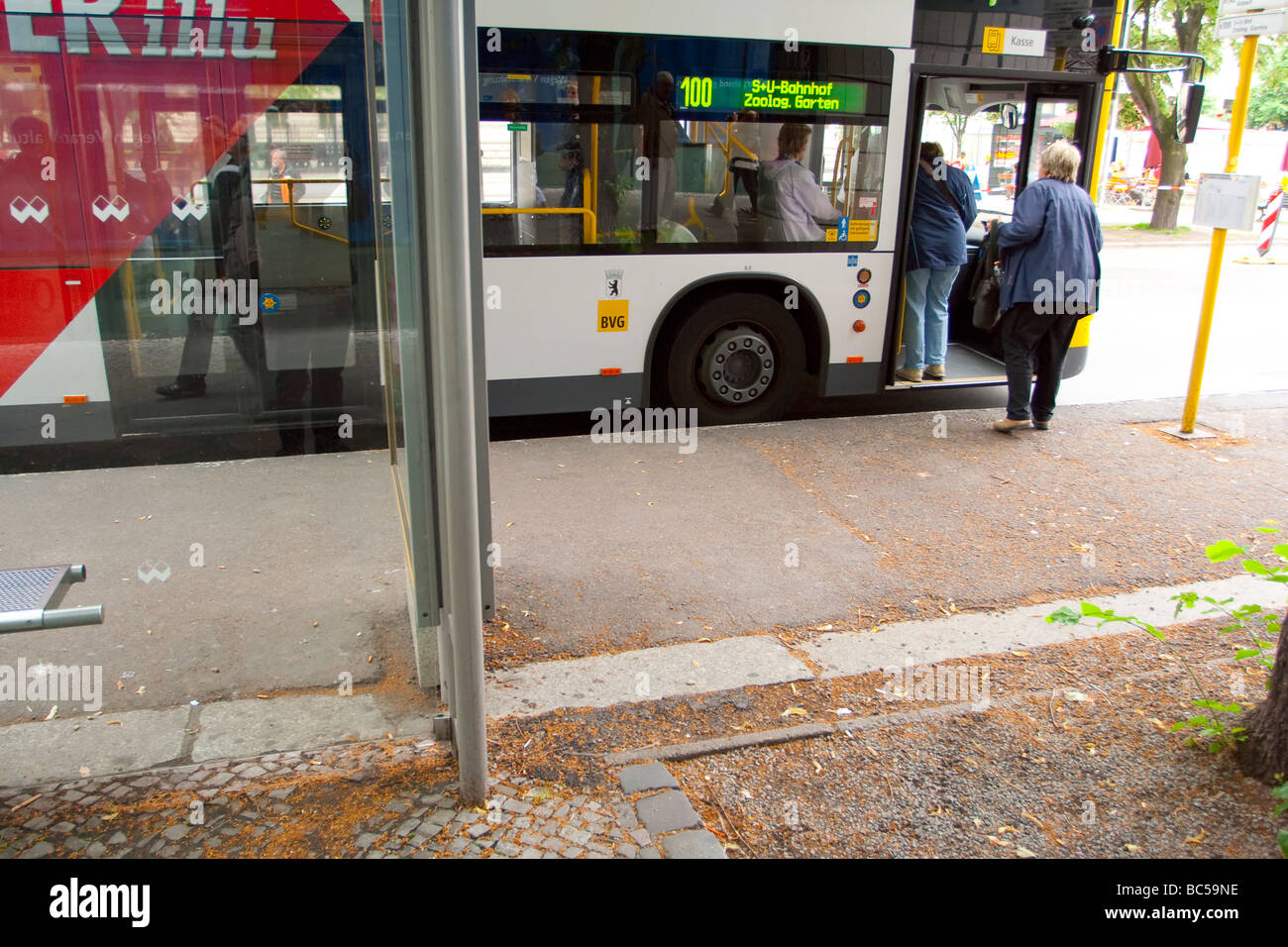 People boarding BVG bus line 100 at a bus stop in Berlin, with ...