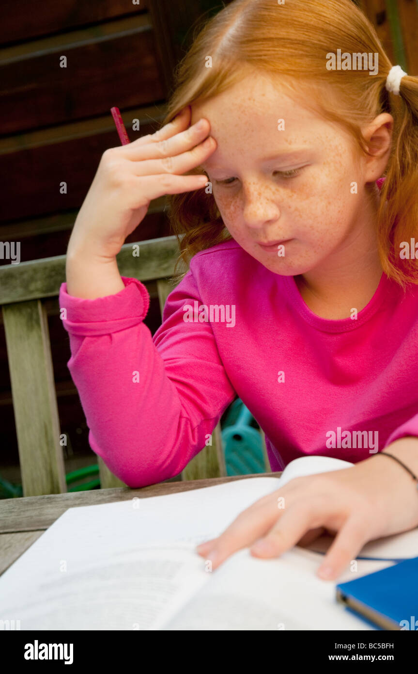 Little girl is making homework in the garden Stock Photo - Alamy