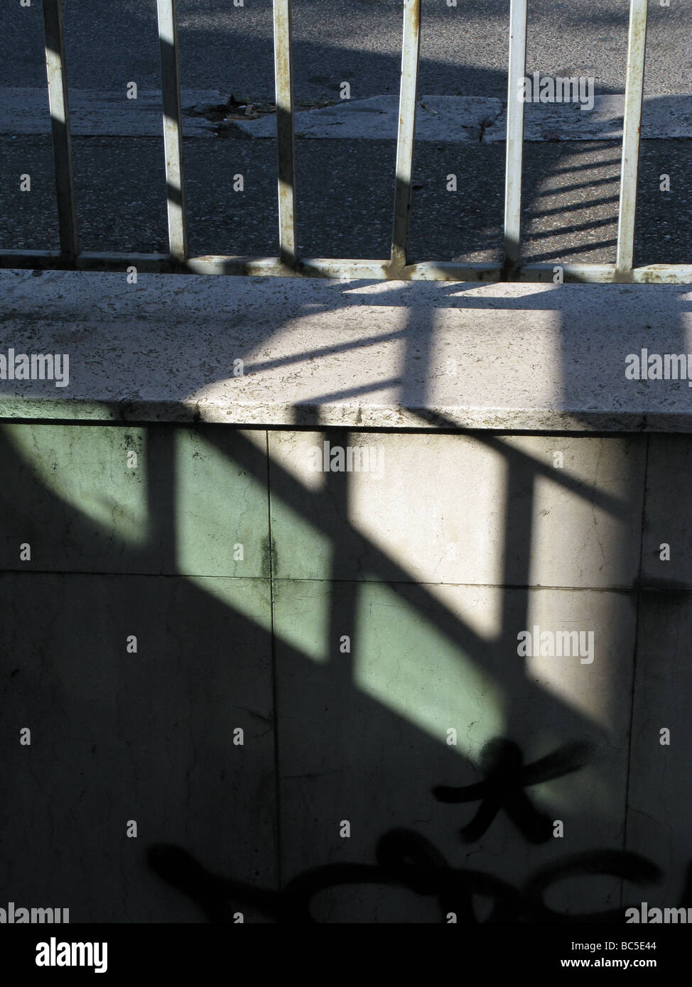 shadow of metal fence on wall in street in city town Stock Photo - Alamy