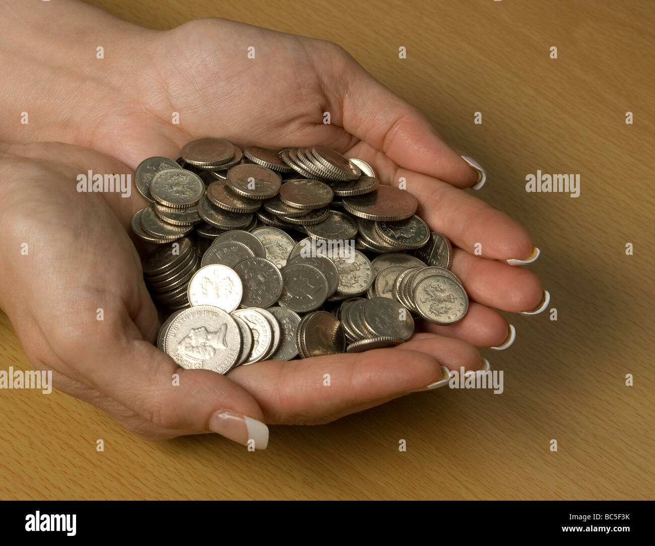 Handful of pound coins hi-res stock photography and images - Alamy