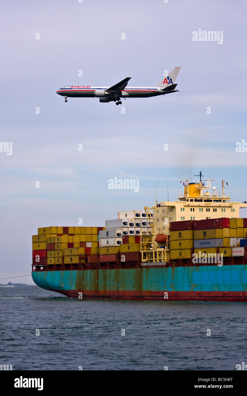 Jet airplane flying over a container ship in a harbor Stock Photo - Alamy