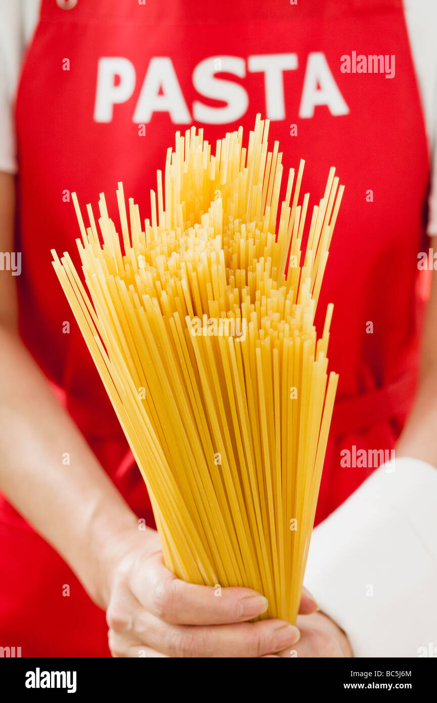 Spaghetti, person with 'pasta' apron in background Stock Photo - Alamy