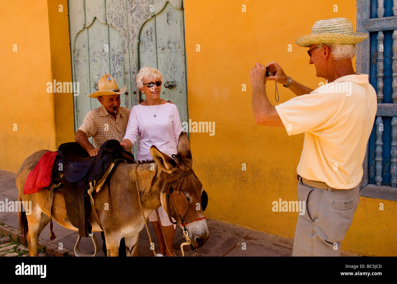 Tourists taking photo of old man riding donkey for tourists in the old ...