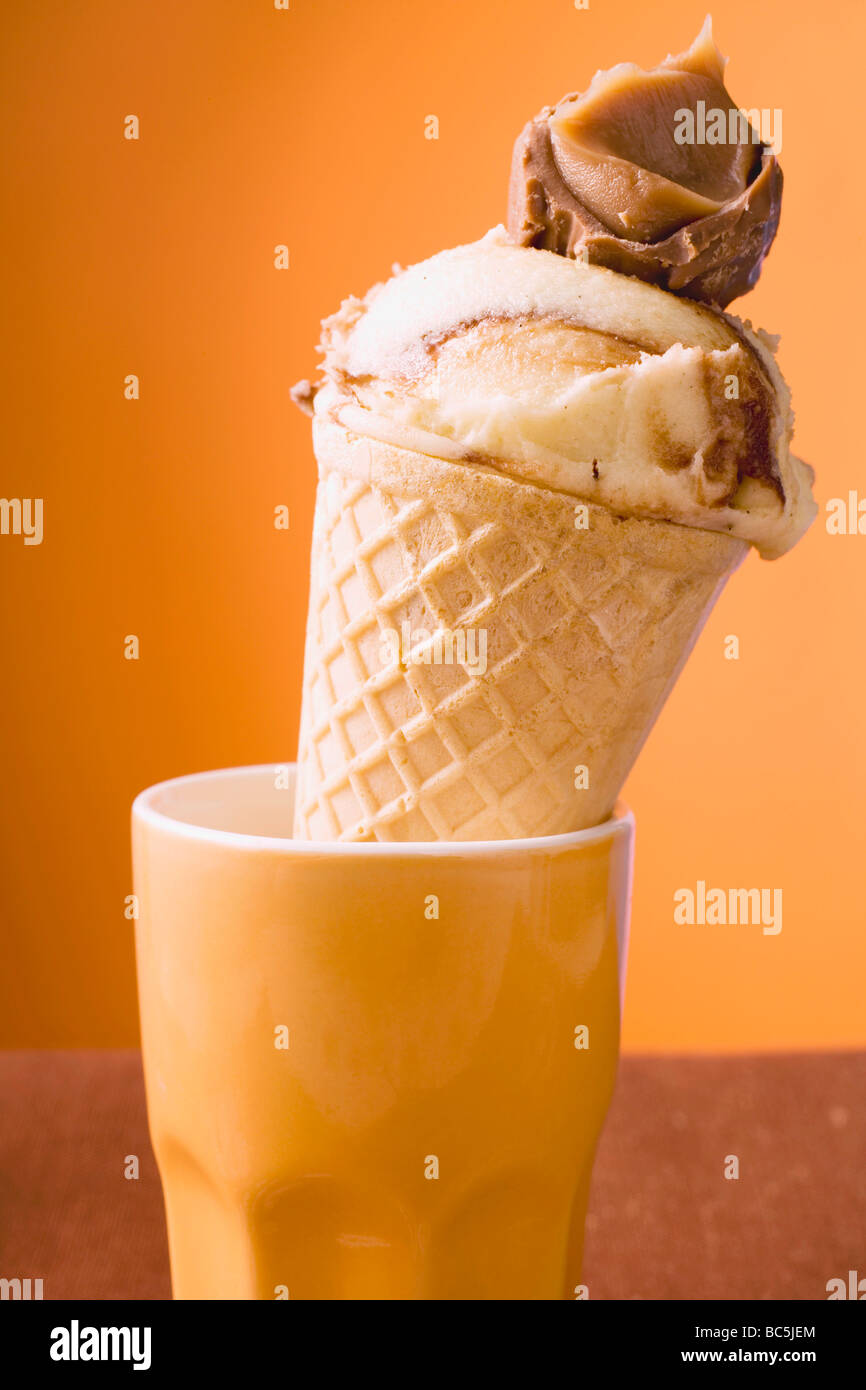 Caramel ice cream in wafer cone in orange beaker Stock Photo - Alamy