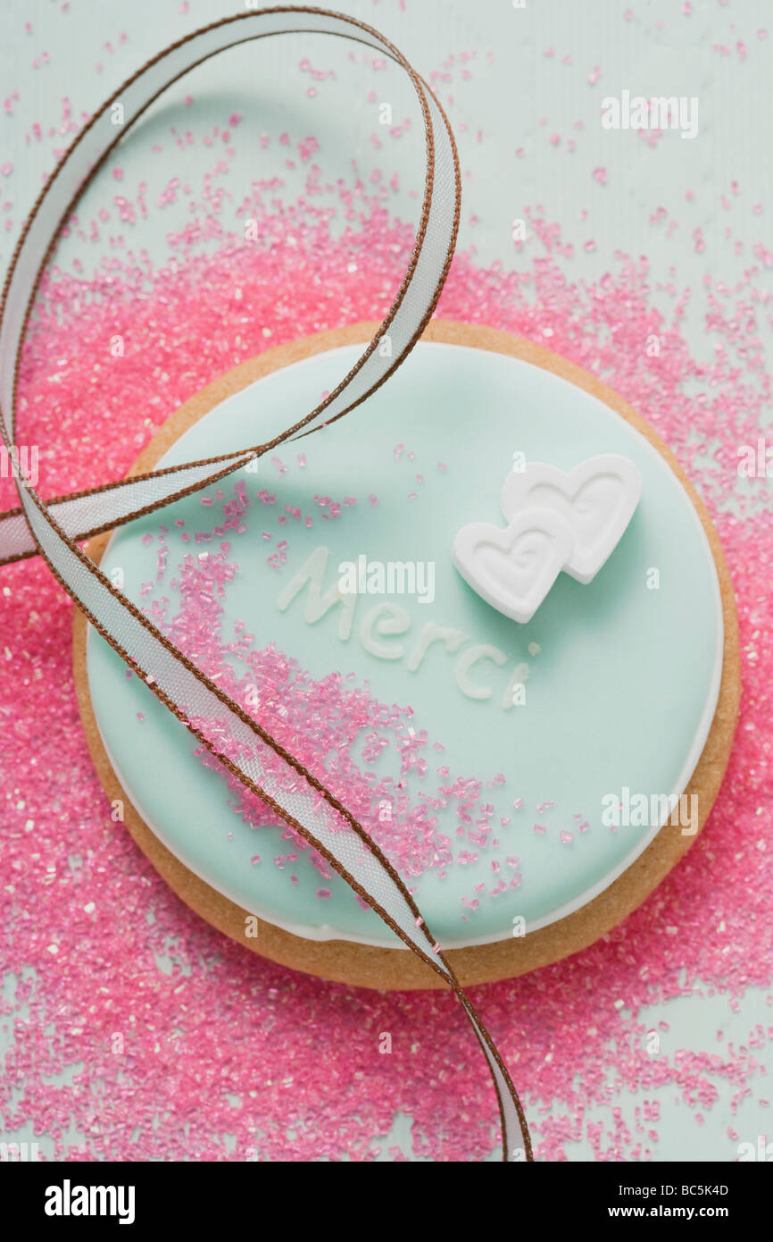 A pastel-coloured biscuit with the word 'Merci' Stock Photo - Alamy