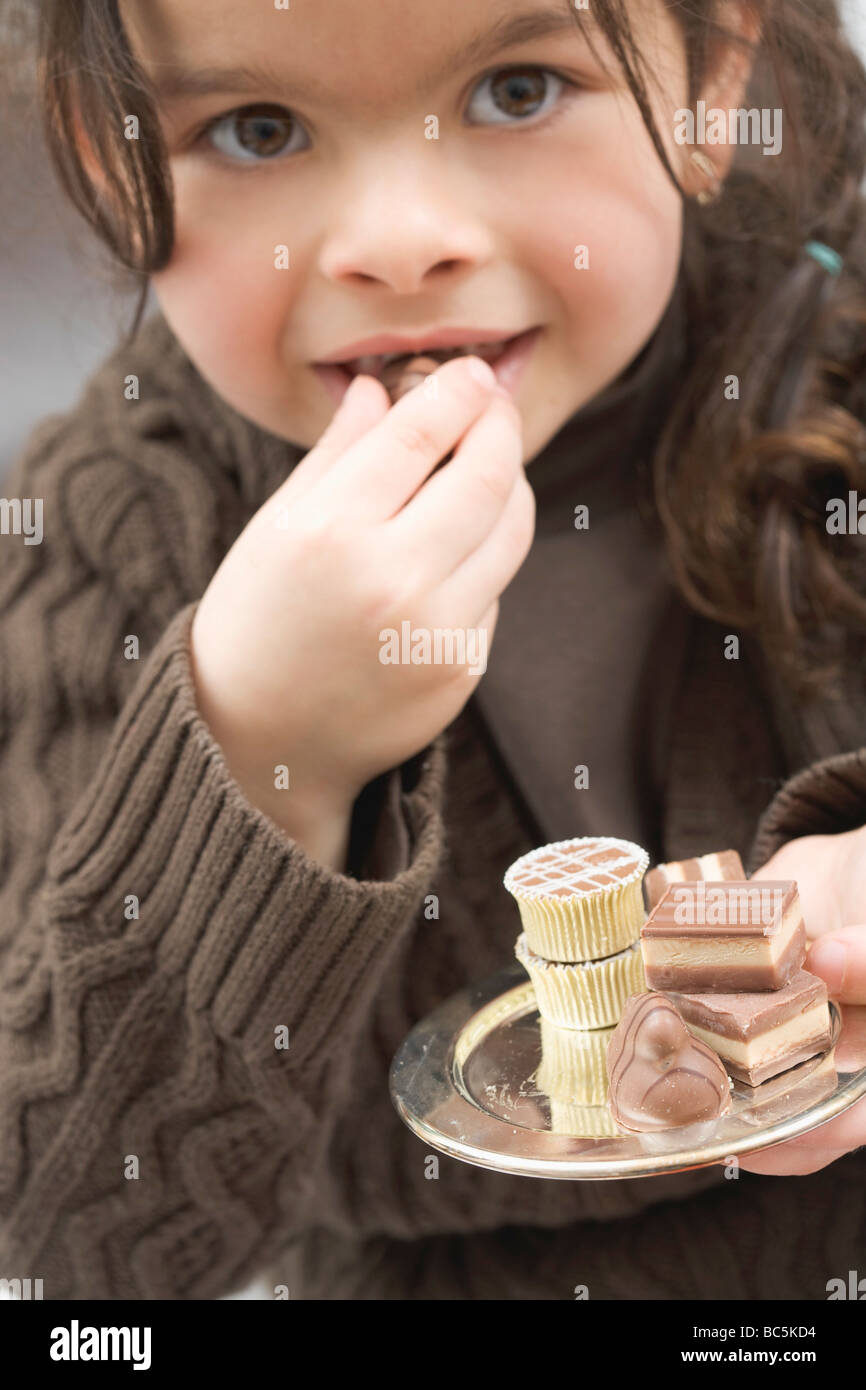 Girl biting into a chocolate Stock Photo - Alamy