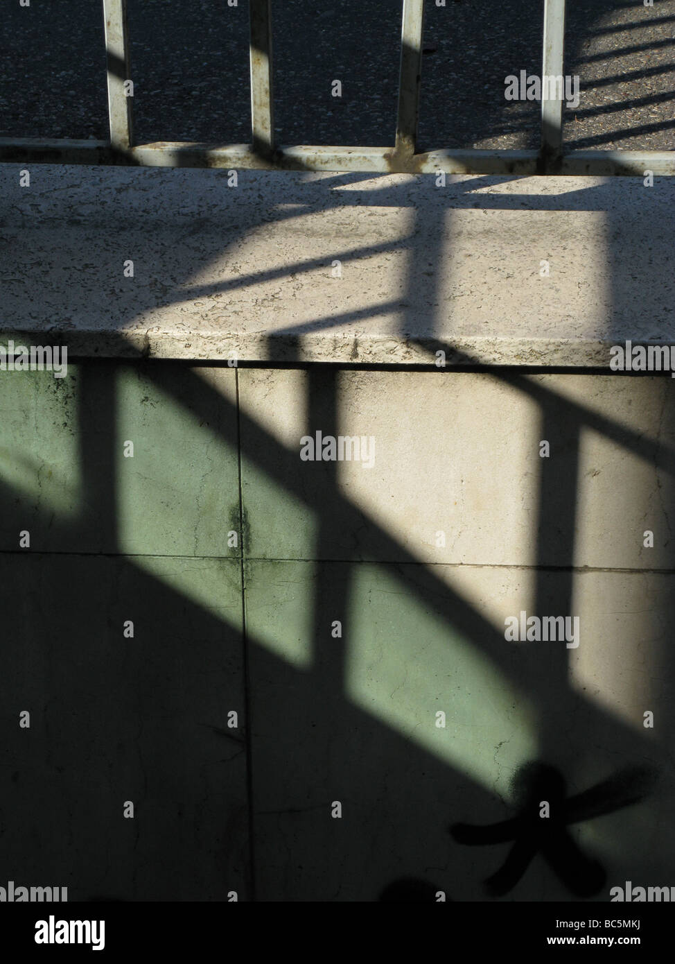 shadow of metal fence on wall in street in city town Stock Photo - Alamy