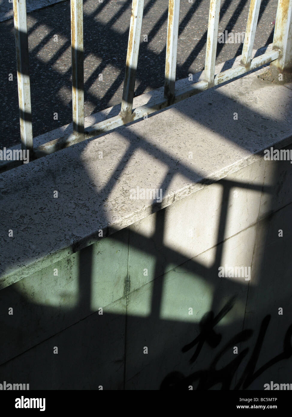 shadow of metal fence on wall in street in city town Stock Photo - Alamy