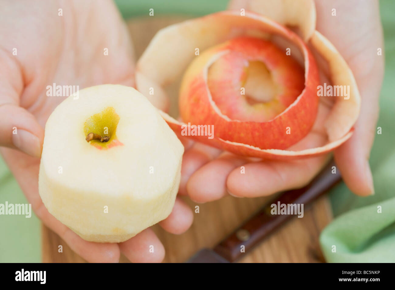 Hands holding a peeled apple and apple peel Stock Photo - Alamy