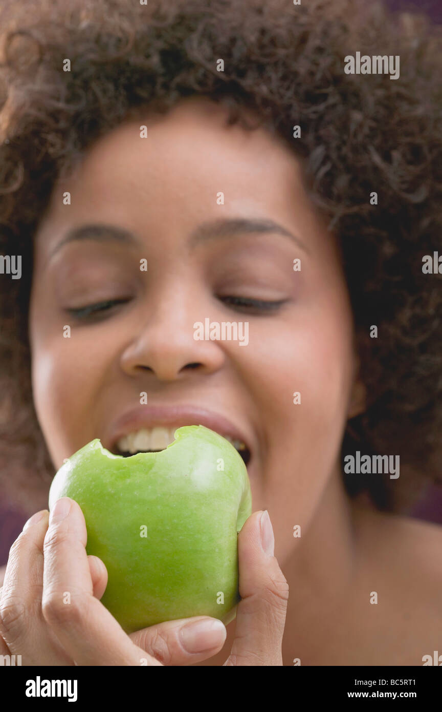 Young woman biting into an apple Stock Photo - Alamy