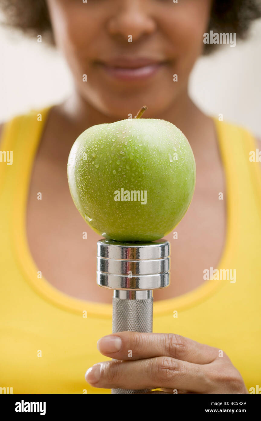 Young woman balancing a fresh apple on a hand weight Stock Photo - Alamy