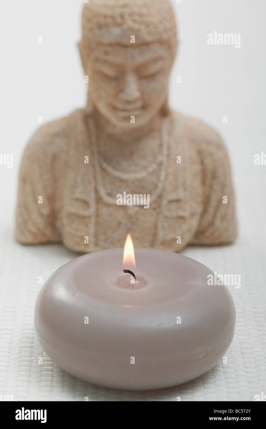 A burning floating candle with religious bust Stock Photo - Alamy