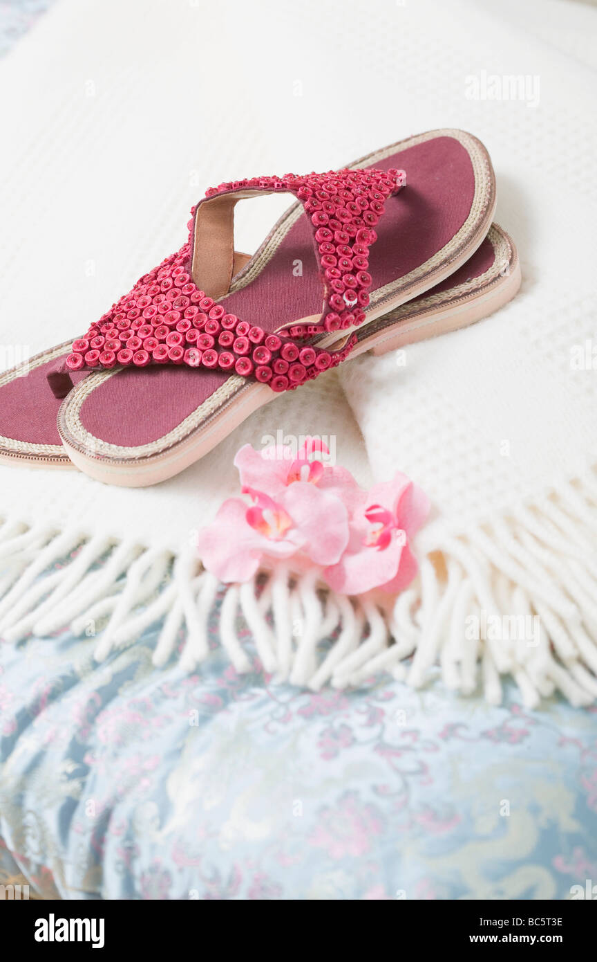Sandals lying on a throw Stock Photo - Alamy