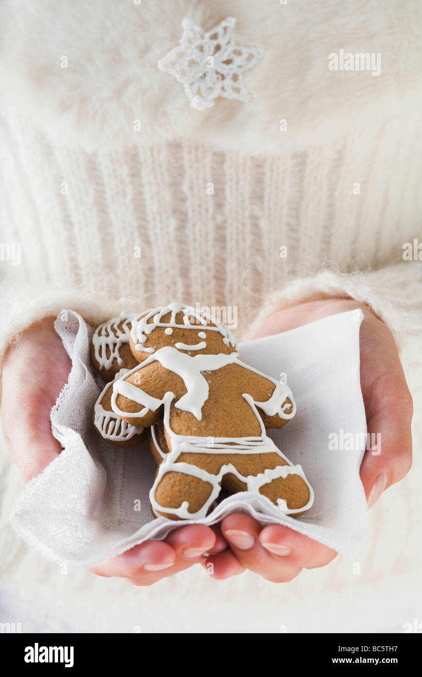 Hands holding two gingerbread men Stock Photo - Alamy