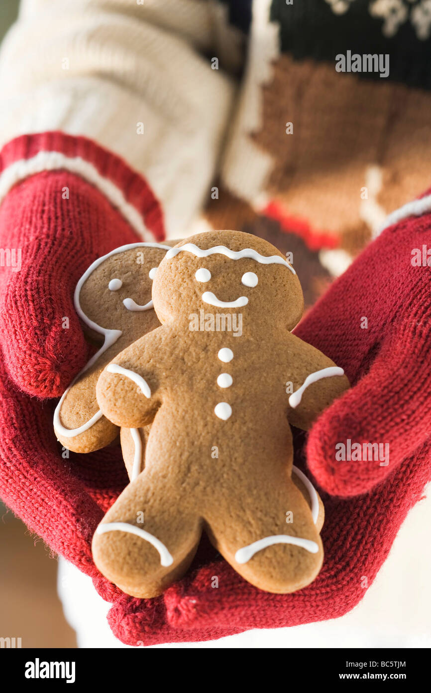 Hands in woollen gloves holding gingerbread men Stock Photo - Alamy
