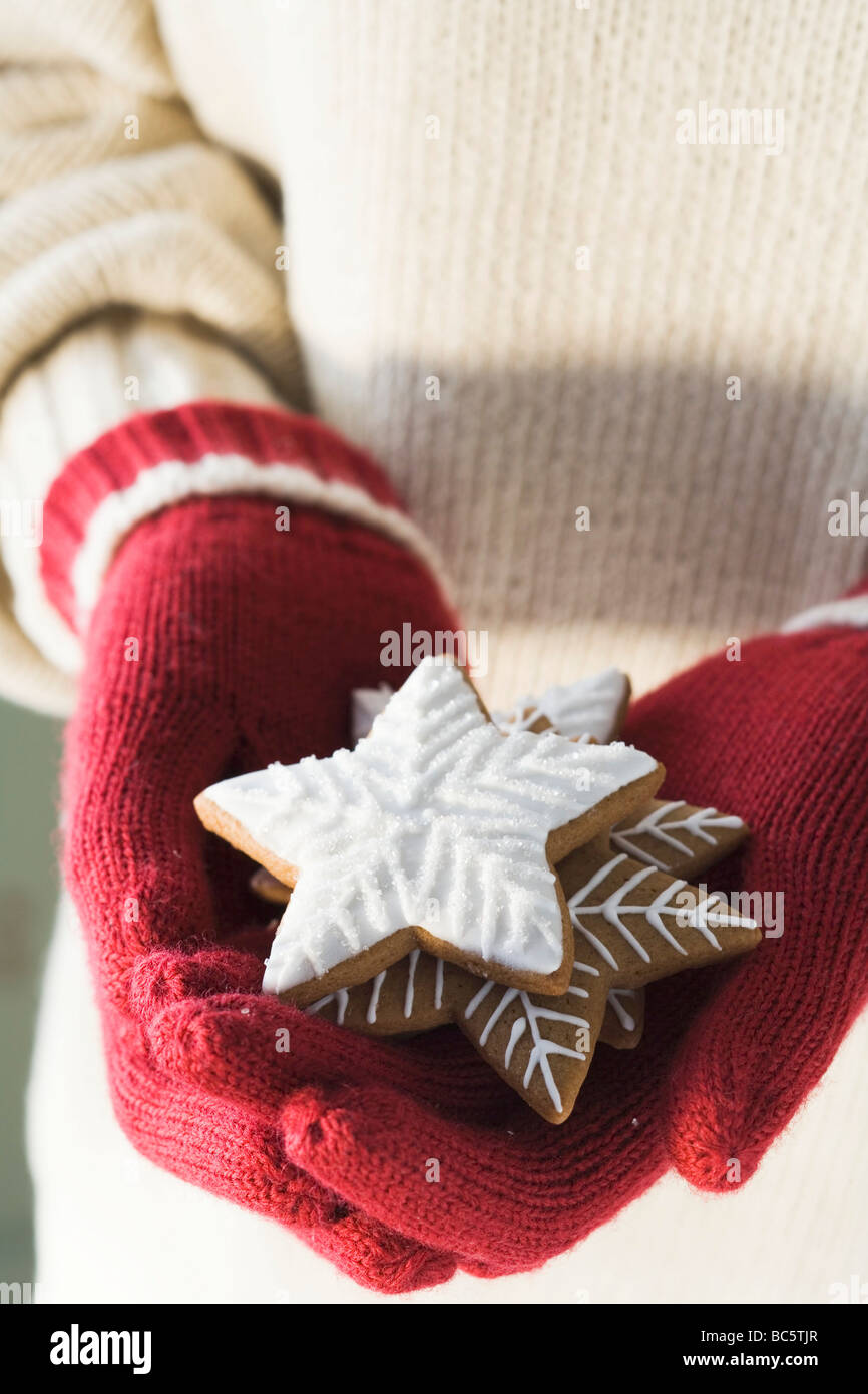 Hands in woollen gloves holding gingerbread stars Stock Photo - Alamy