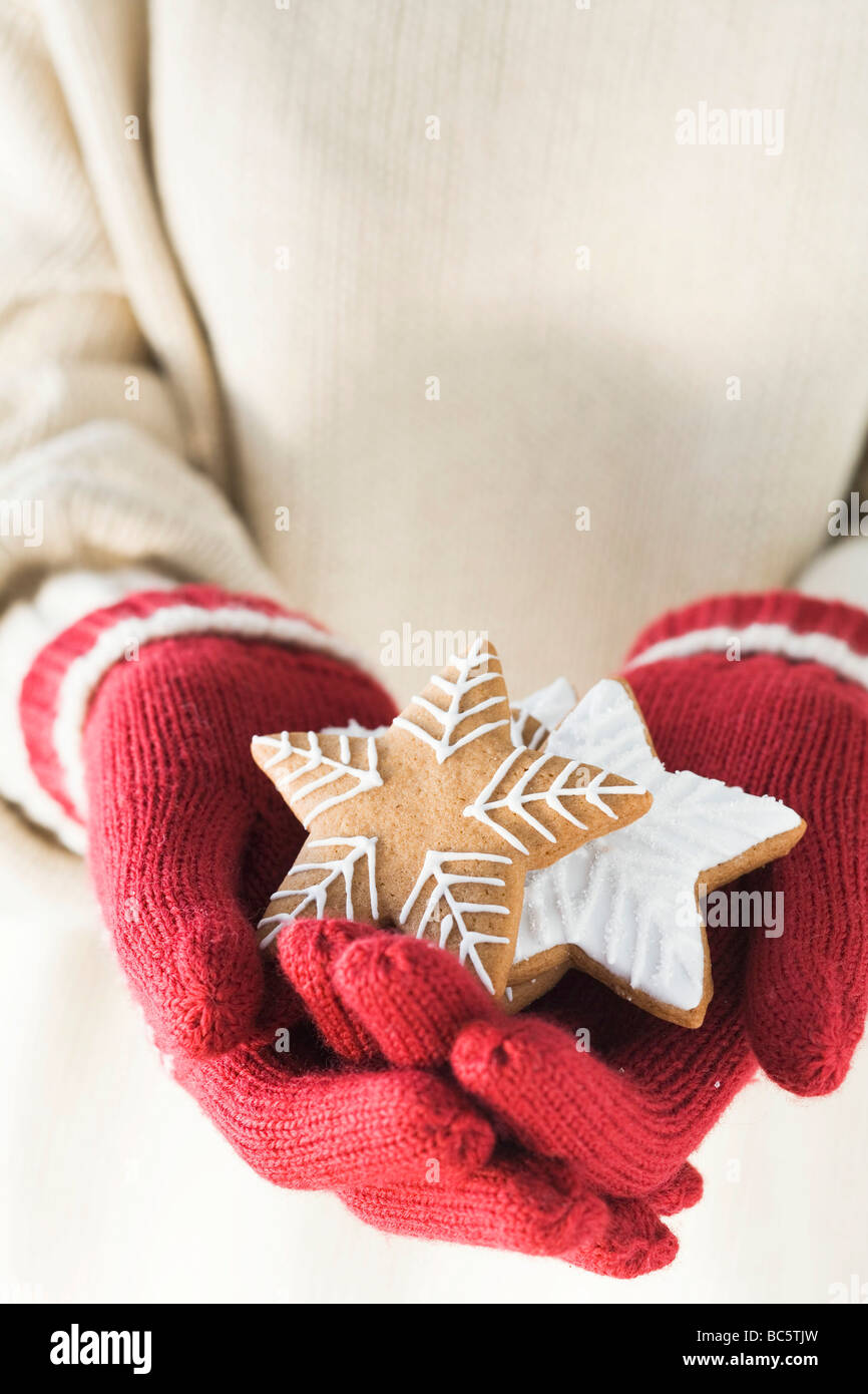 Hands in woollen gloves holding gingerbread stars Stock Photo - Alamy