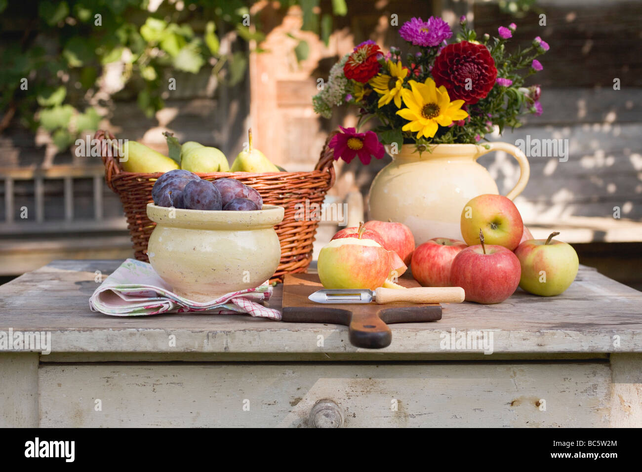 Rustic fruit still life on garden table in front of farmhouse Stock ...