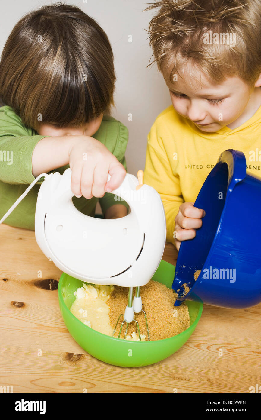 Two children mixing cake mixture Stock Photo - Alamy