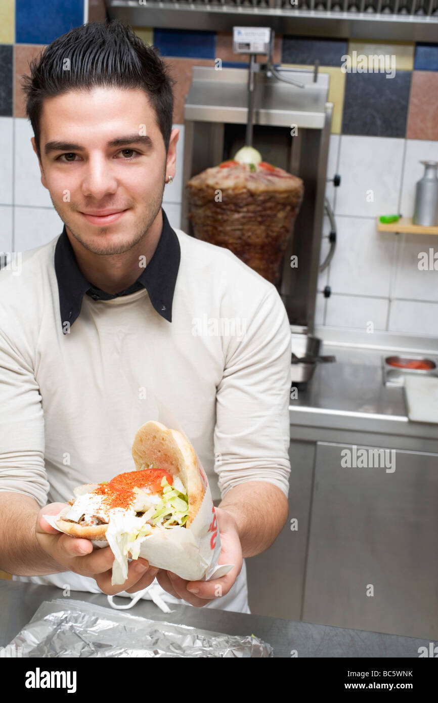 Young chef holding a döner kebab Stock Photo - Alamy