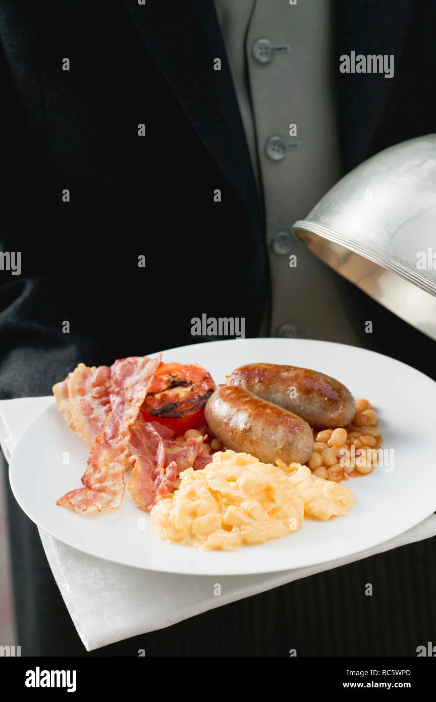 Butler serving English breakfast on plate with dome cover Stock Photo ...