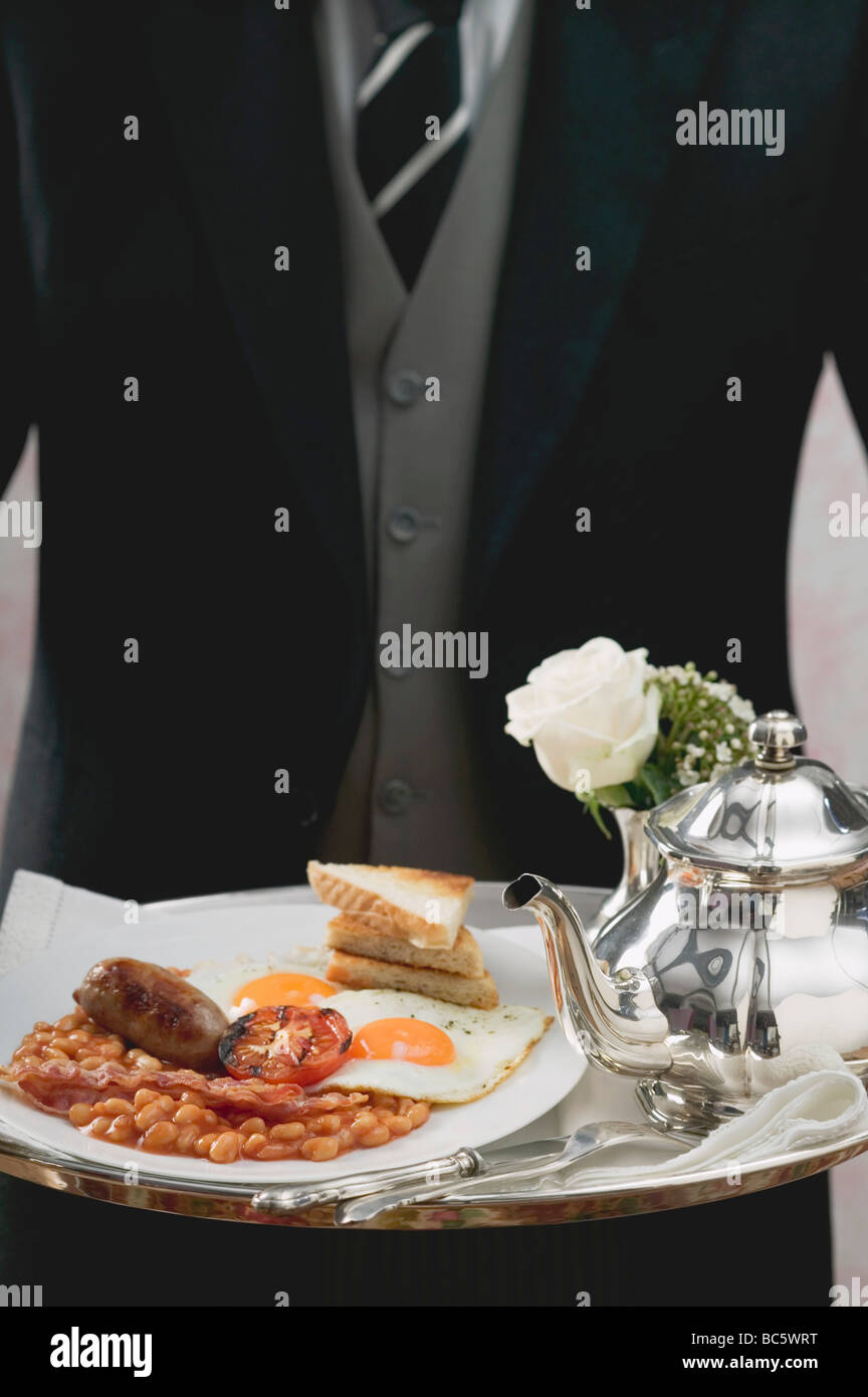 Butler serving English breakfast on tray Stock Photo - Alamy