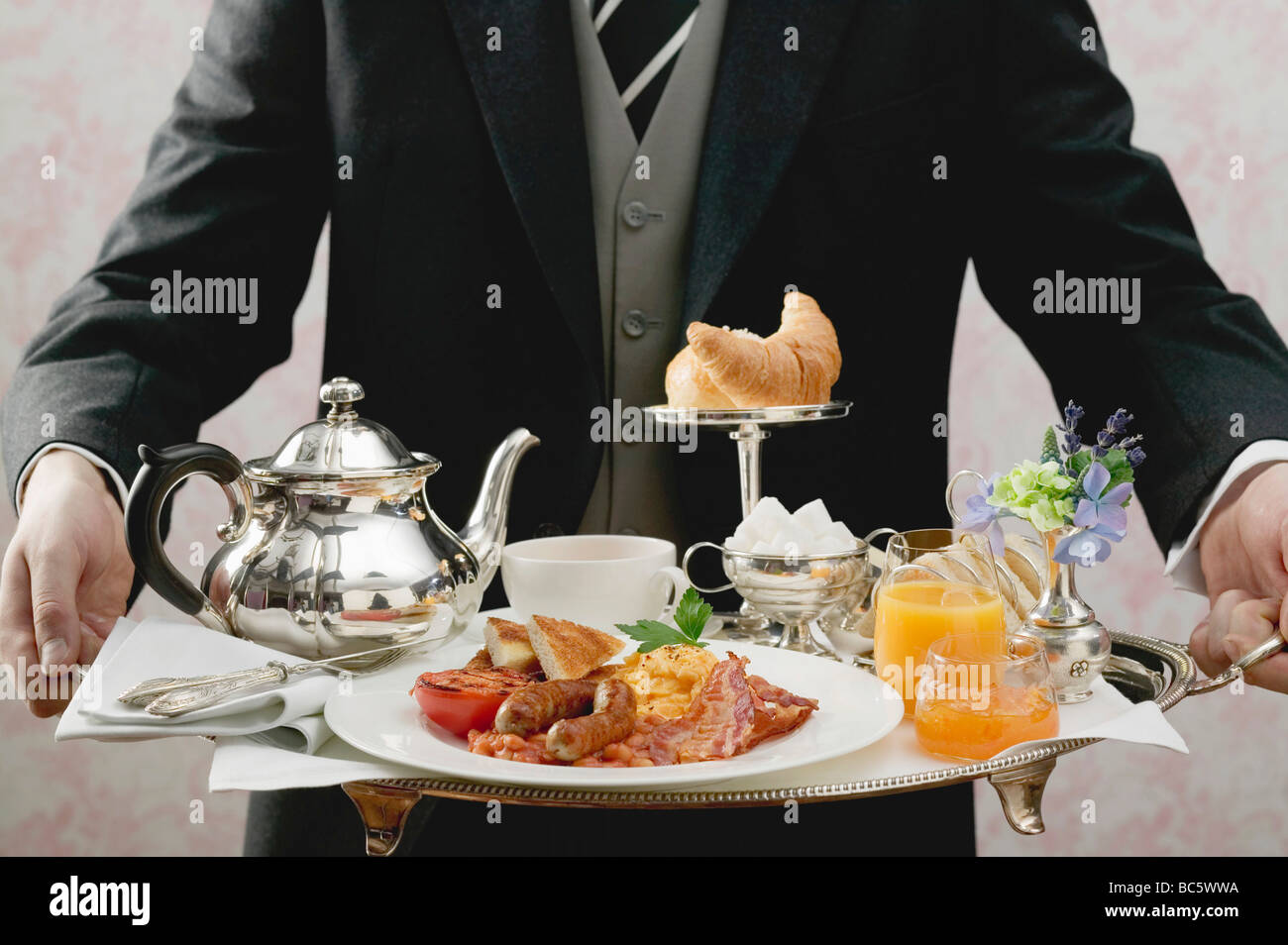 Butler serving English breakfast on tray Stock Photo - Alamy