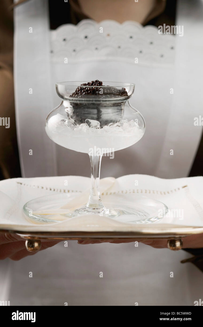 Chambermaid serving caviar in stemmed glass on tray Stock Photo - Alamy