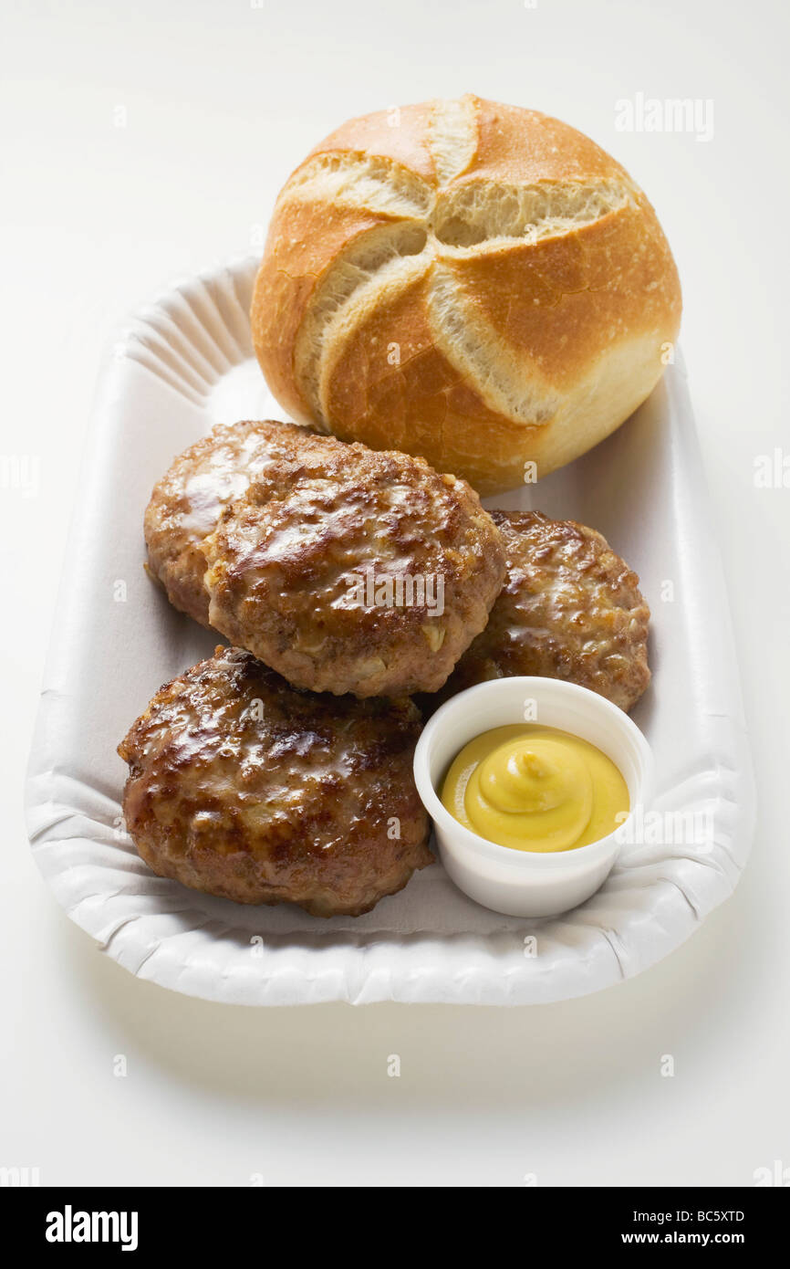 Burgers with mustard and bread roll on paper plate Stock Photo - Alamy