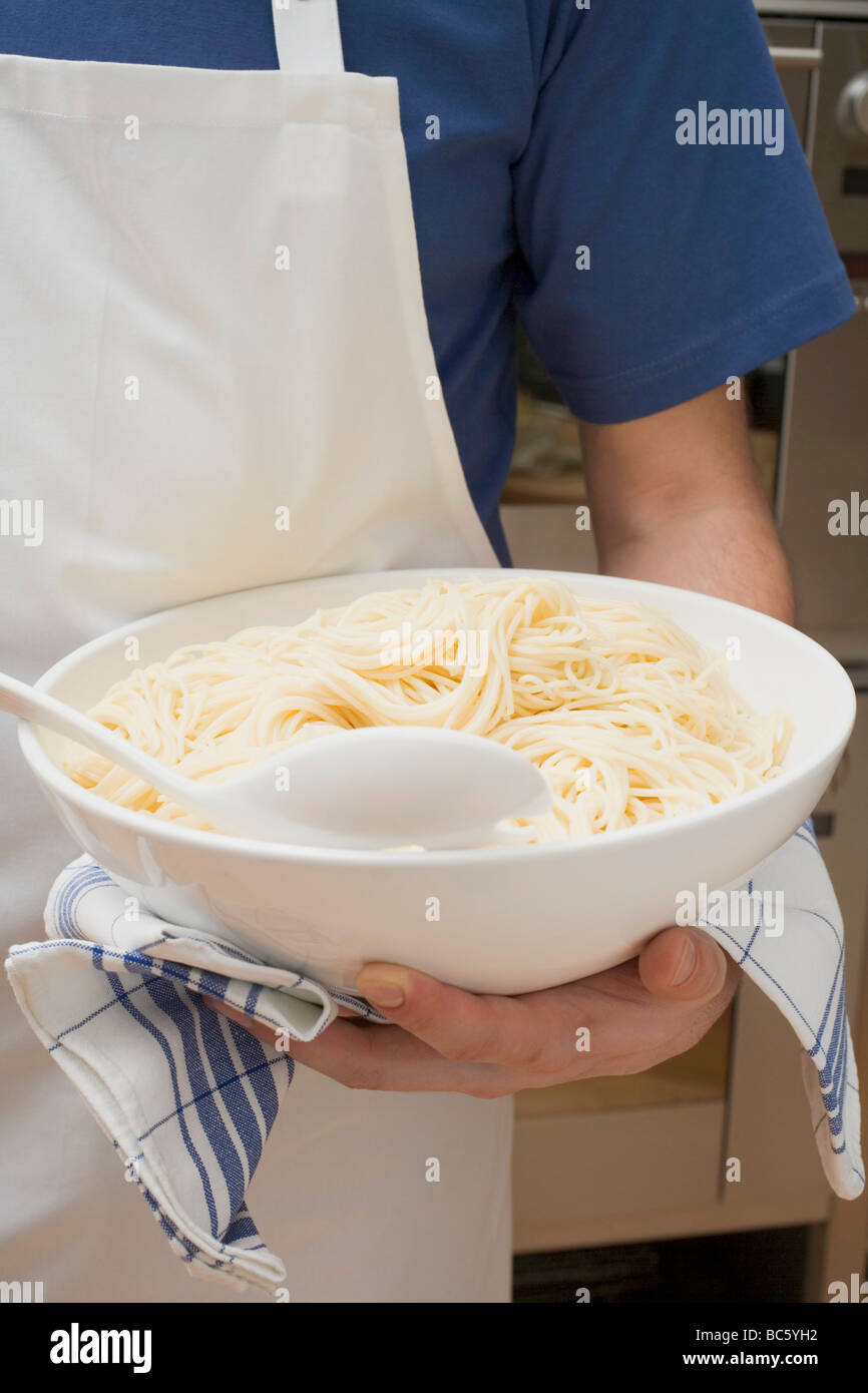 Person holding bowl of cooked spaghetti Stock Photo - Alamy