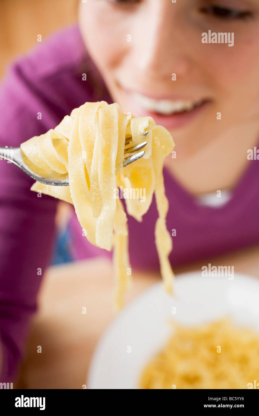 Young woman eating ribbon pasta Stock Photo - Alamy