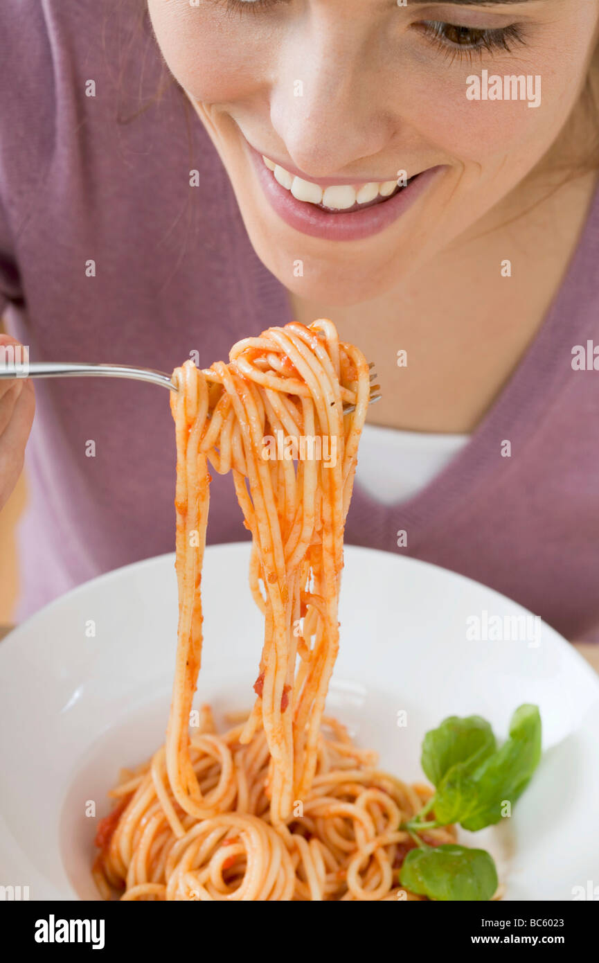 Woman eating spaghetti with tomato sauce Stock Photo - Alamy