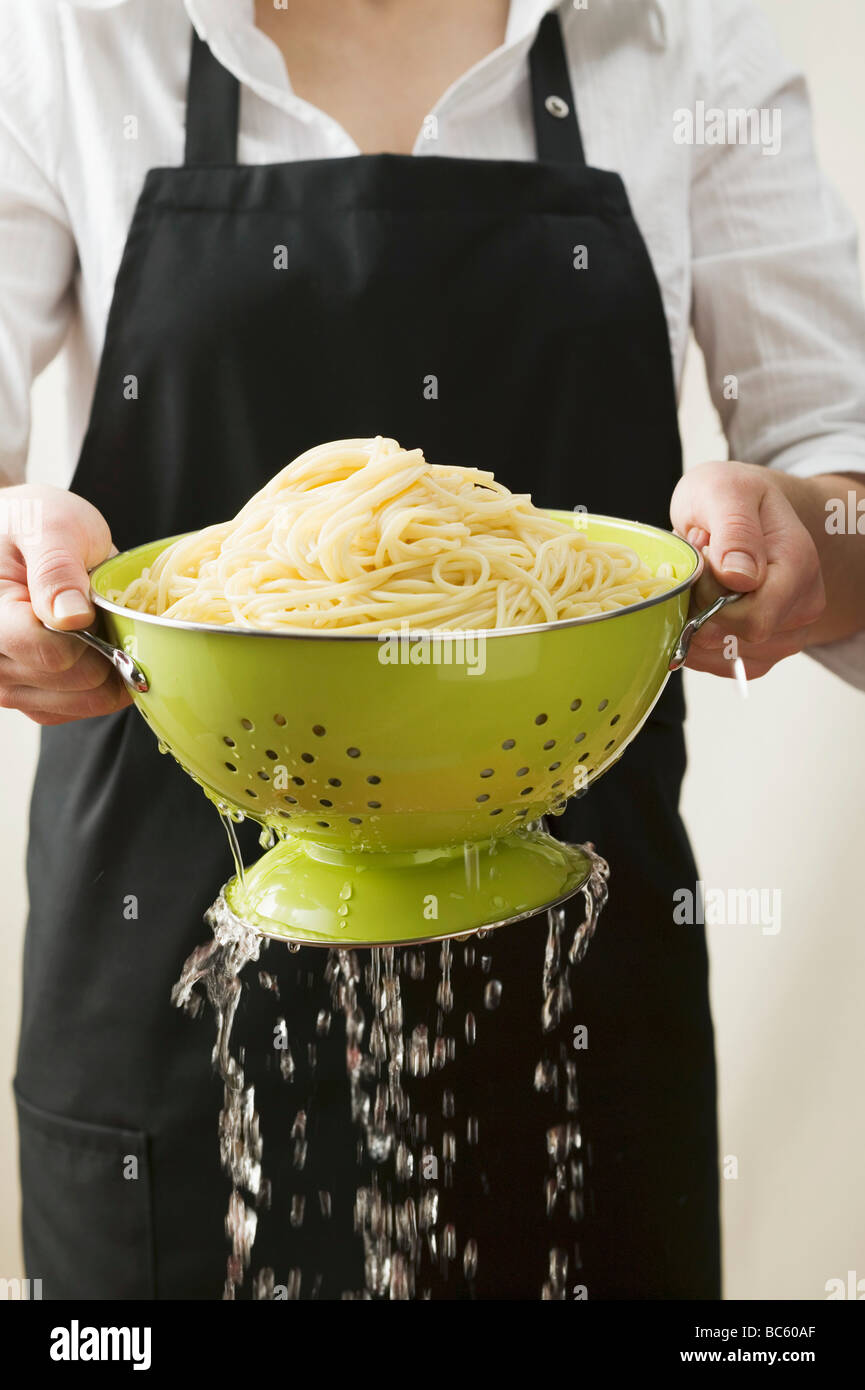 Draining cooked spaghetti Stock Photo - Alamy