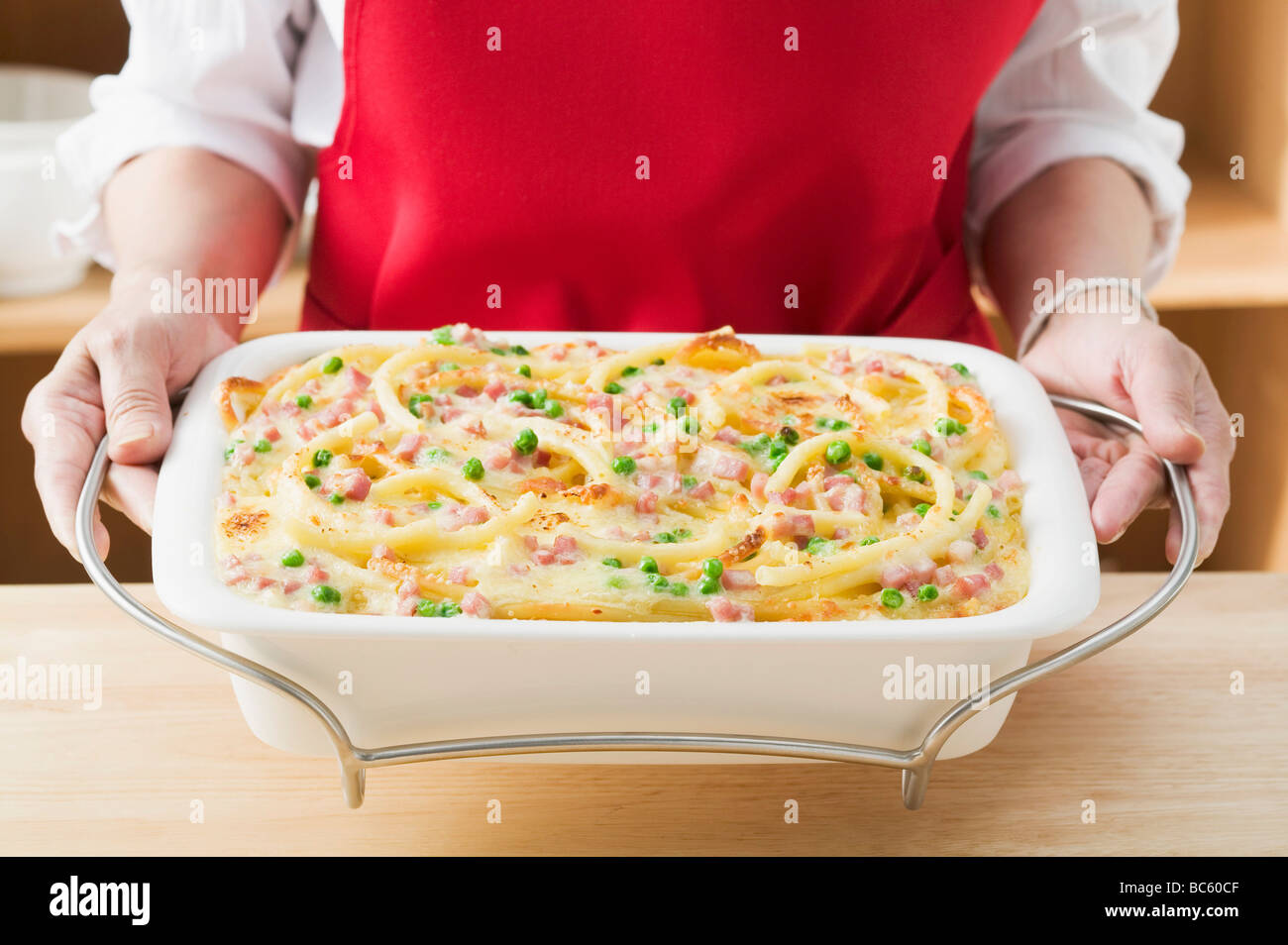 Woman serving macaroni bake Stock Photo - Alamy