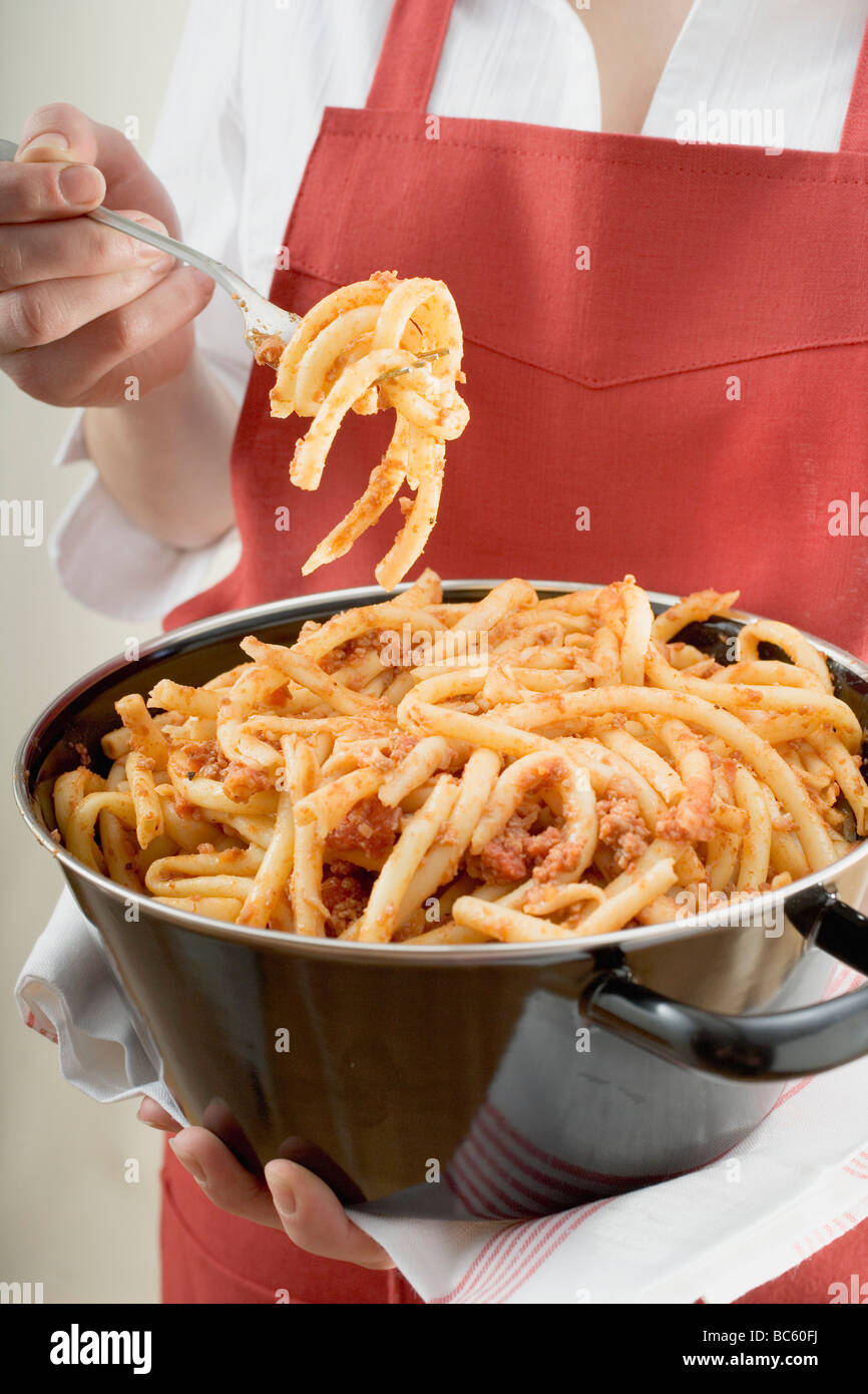 Woman eating macaroni with mince sauce out of pan Stock Photo - Alamy