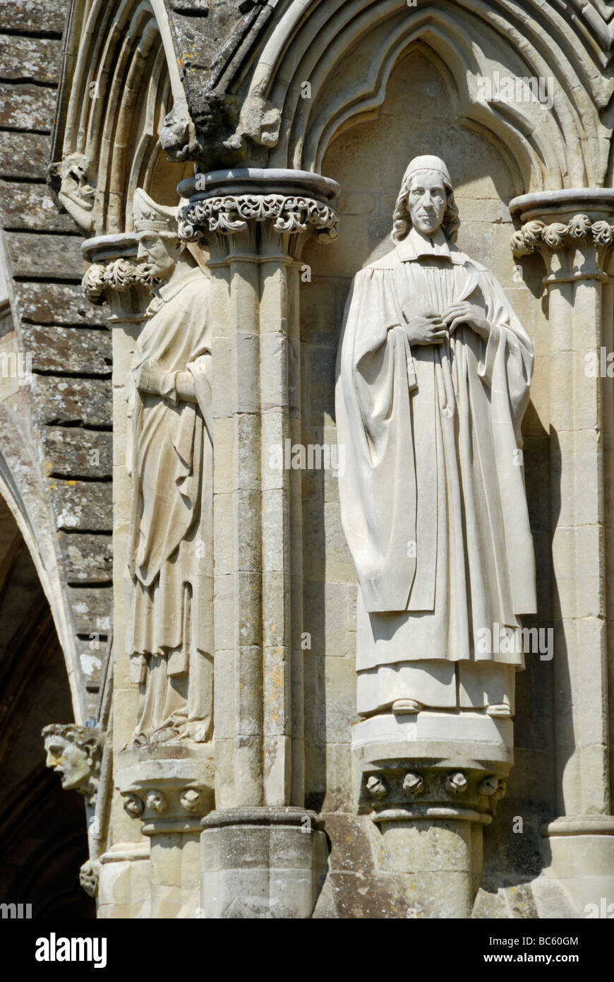 Statues of two clergymen on exterior of Salisbury Cathedral Wiltshire ...
