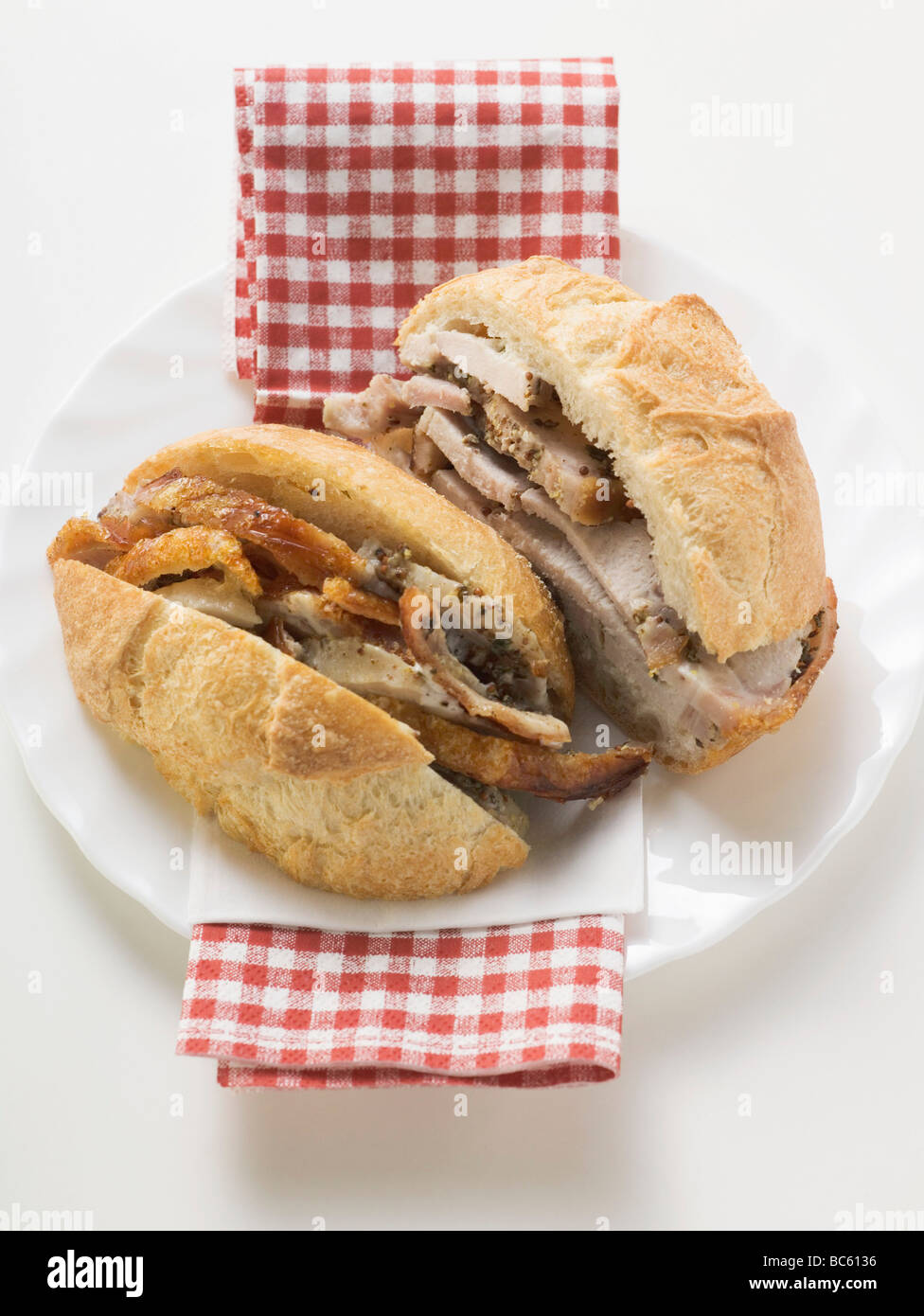 Roast pork in bread roll, halved, on napkin Stock Photo - Alamy