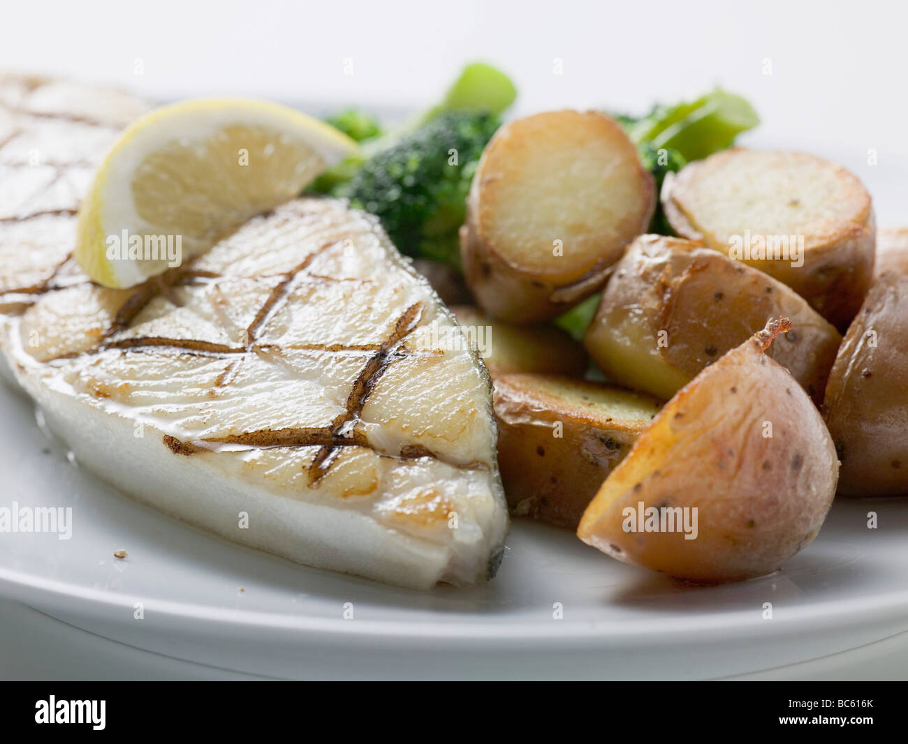 Grilled cod steak with potatoes Stock Photo - Alamy