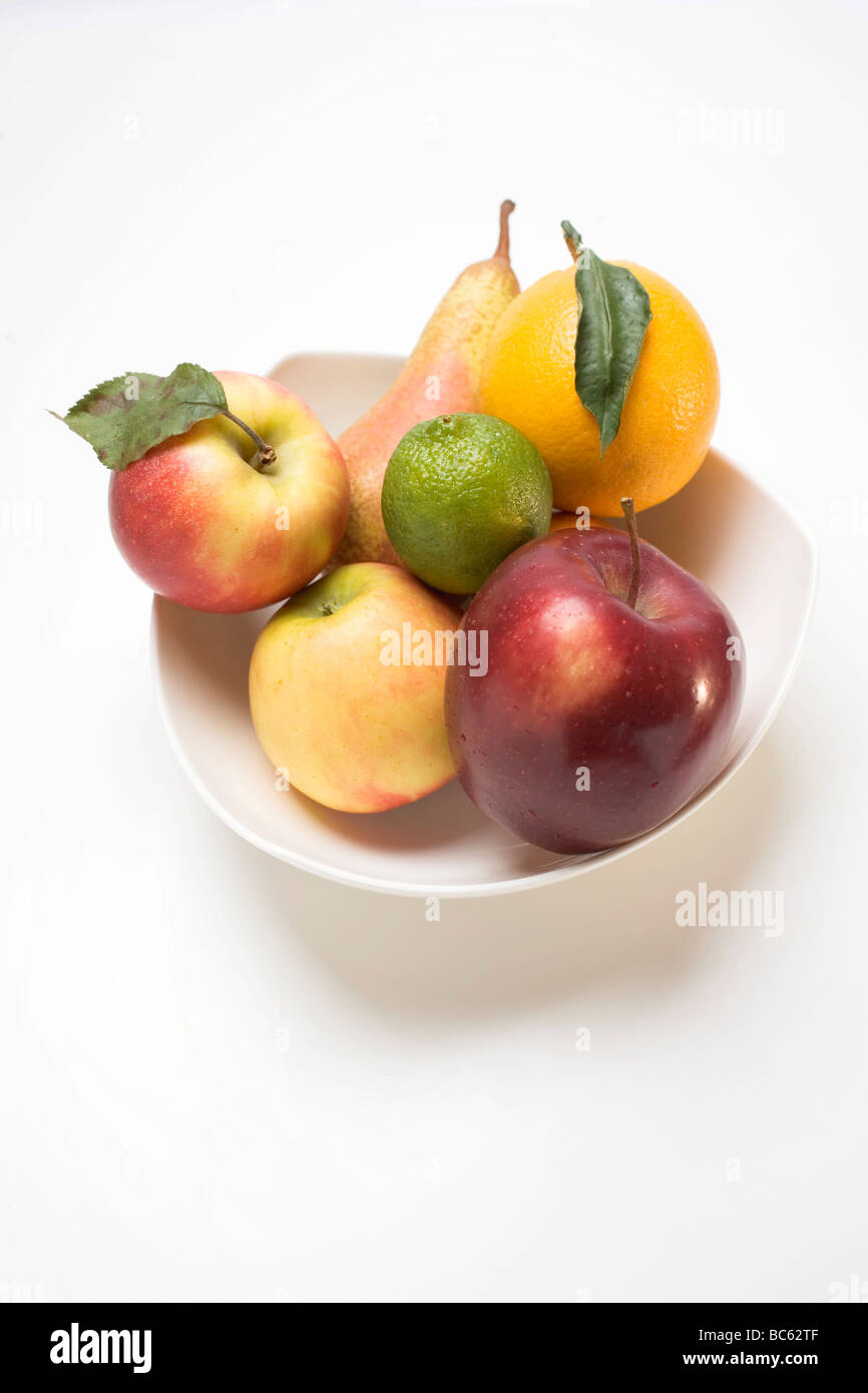 Core fruit and citrus fruit in white bowl Stock Photo - Alamy