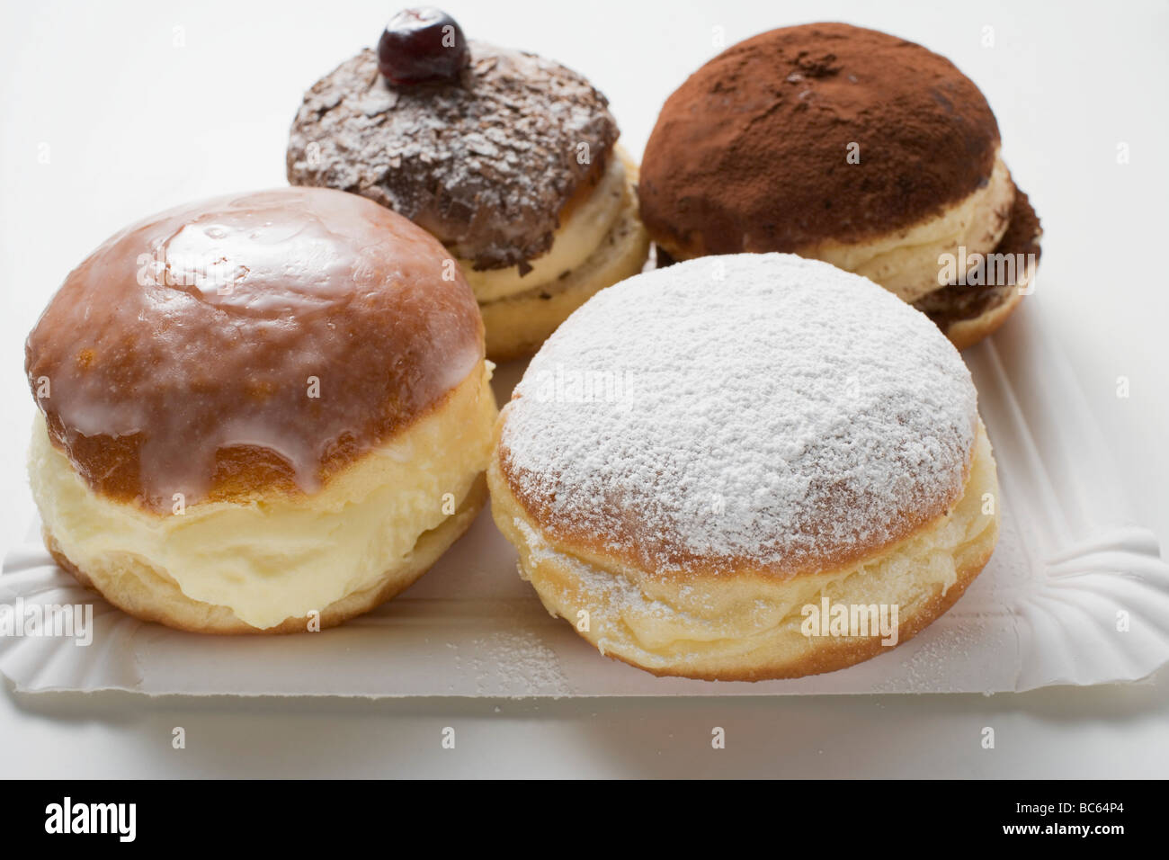 Four different doughnuts on paper plate Stock Photo - Alamy