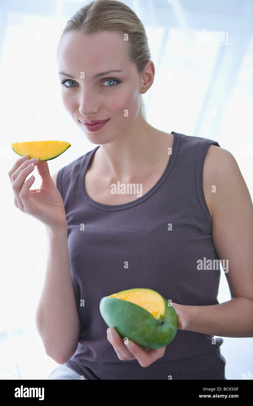 Young woman holding mango, portrait Stock Photo - Alamy