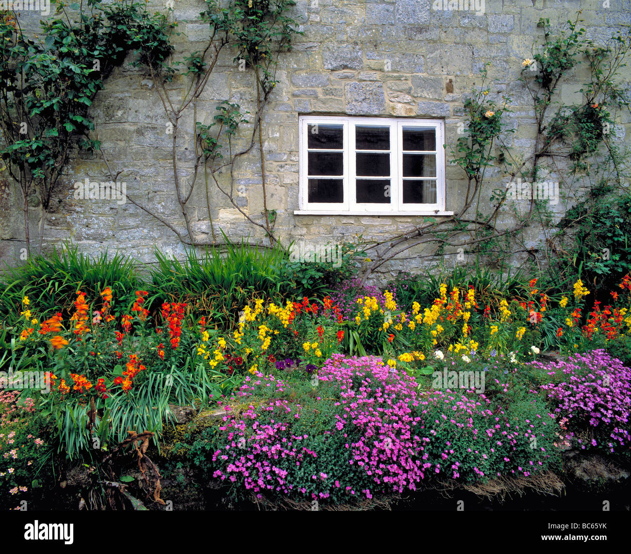 Flowers fill the garden of a stone house in Teffont Magna in Wiltshire ...