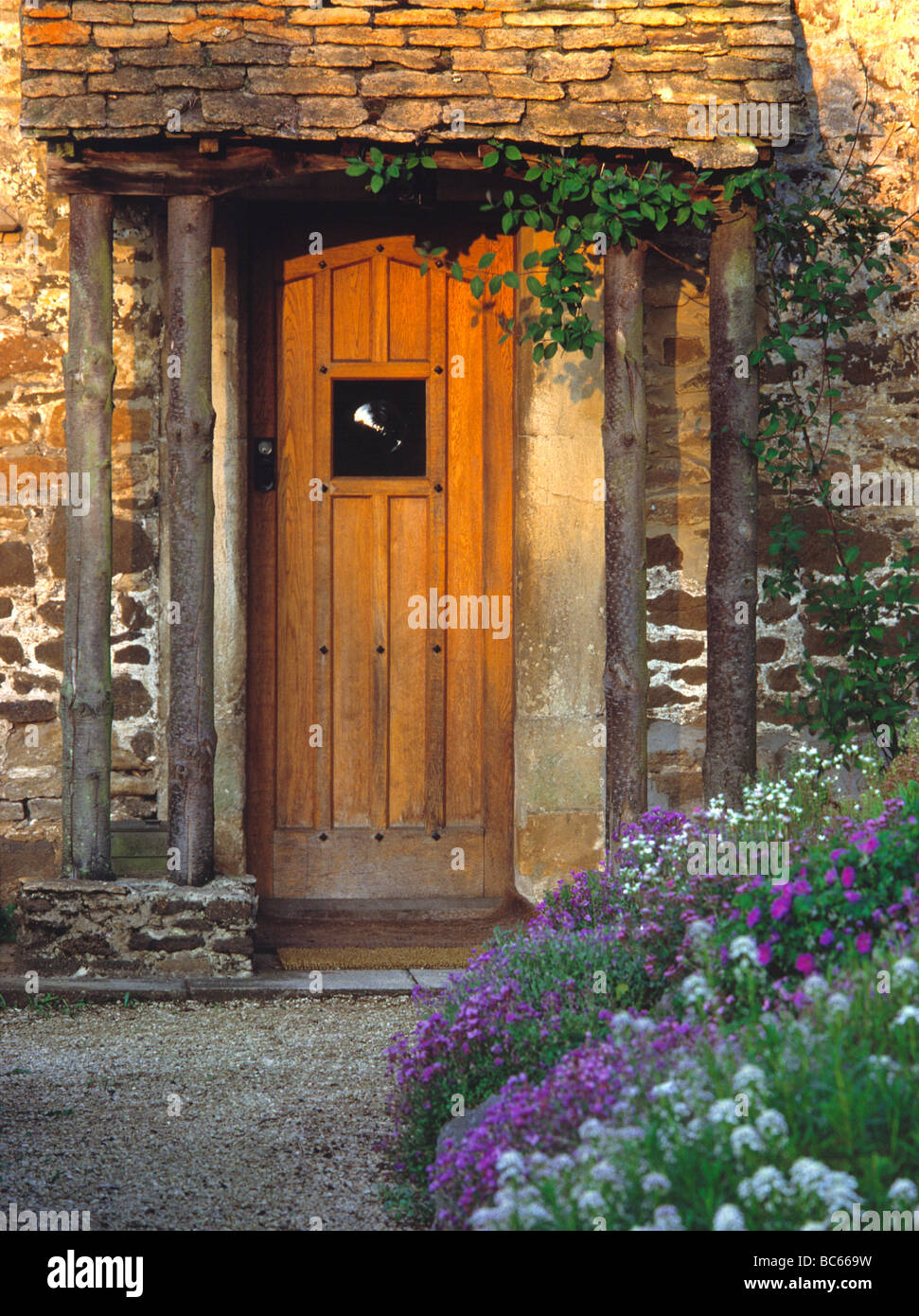 An old wooden door welcomes visitors to a thatched roofed cottage in ...