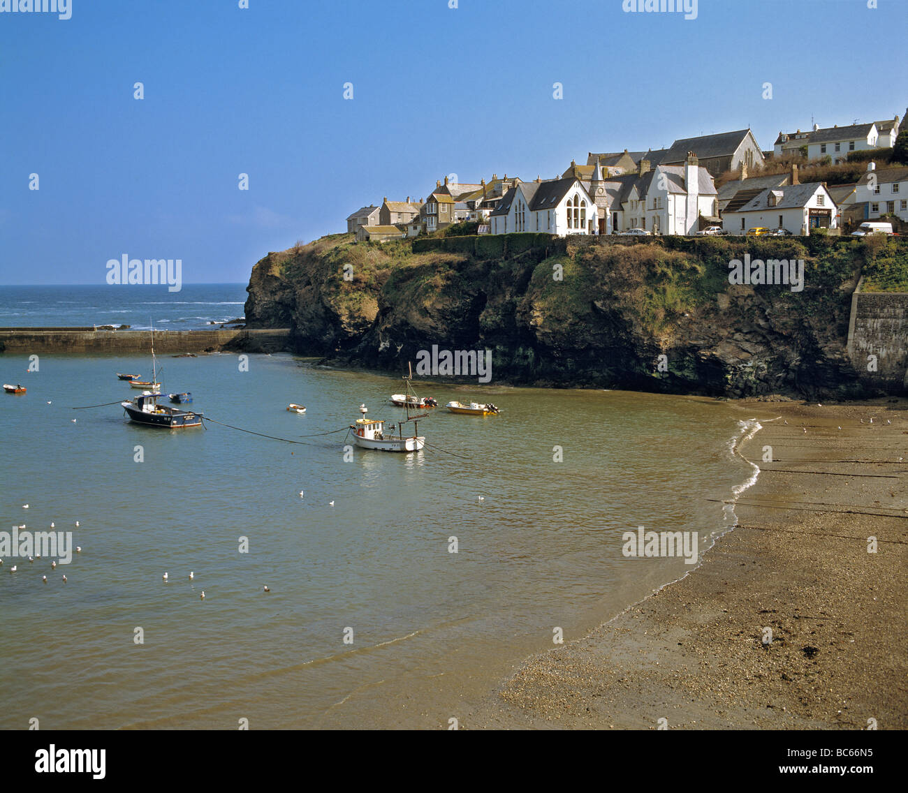Fishing boats sit calmly in the harbor at Port Isaac Cornwall England ...