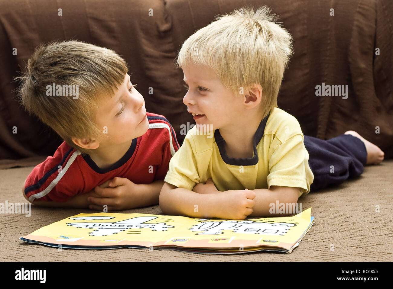 Brothers reading a book together Stock Photo - Alamy