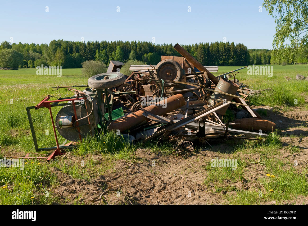 Scrapheap on a green field, with forests in the background Stock Photo ...