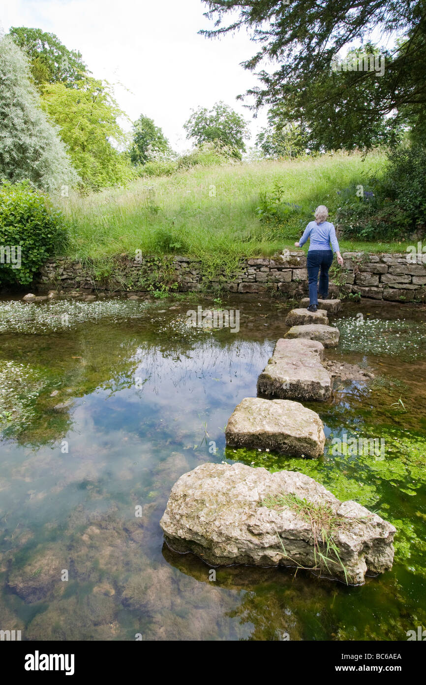 Back view of female at the end of a series of stepping stones over a ...