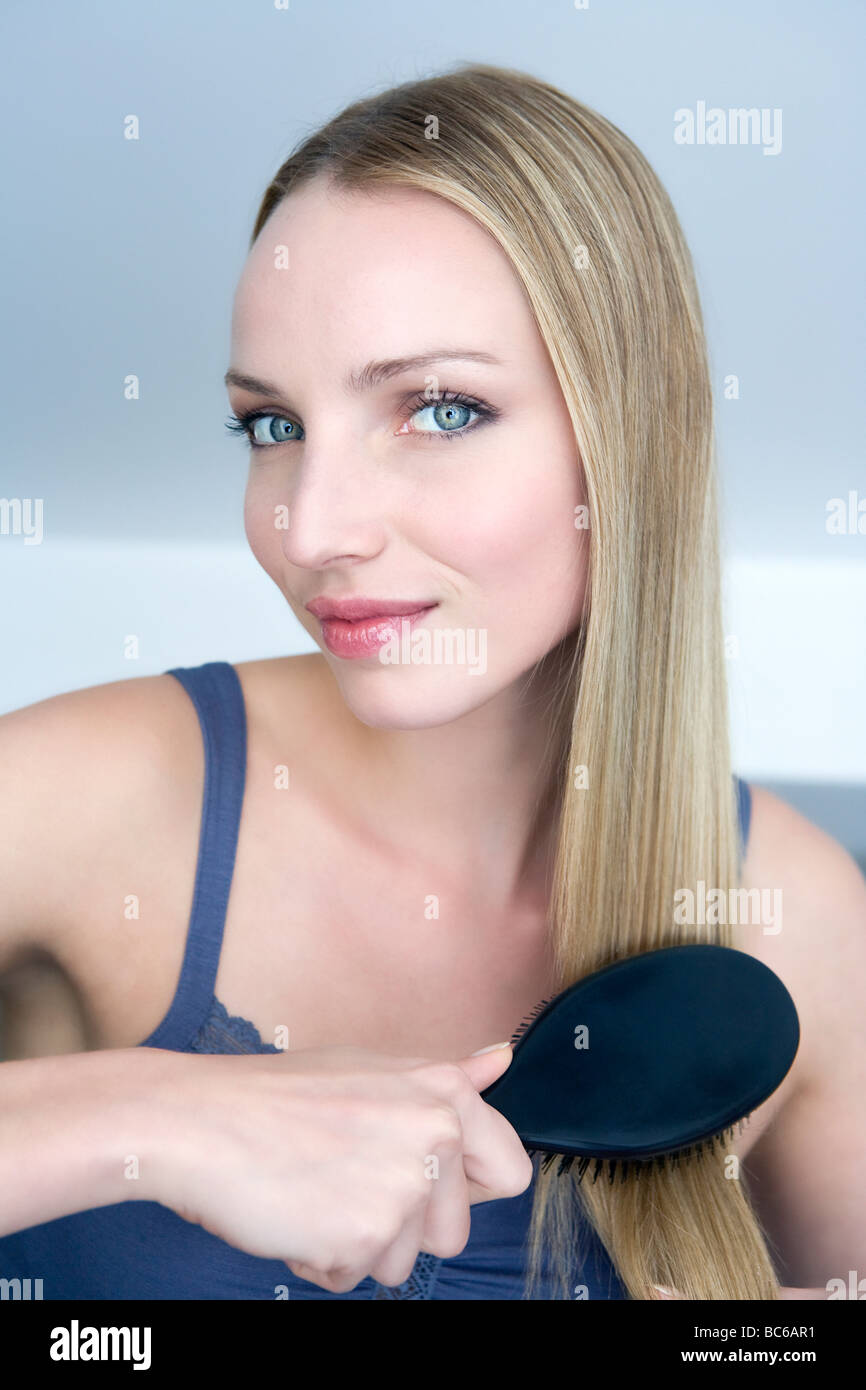Young woman brushing her hair, portrait Stock Photo - Alamy