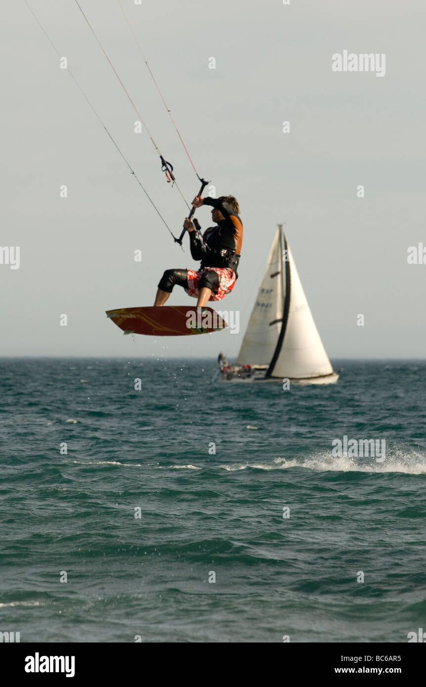 Kite surfer airborne with sailing yacht in background Stock Photo - Alamy